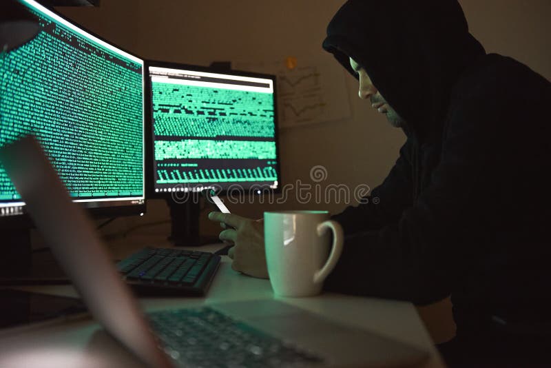Computer Security. Young Man in Black Hoodie Using Multiple Computers ...