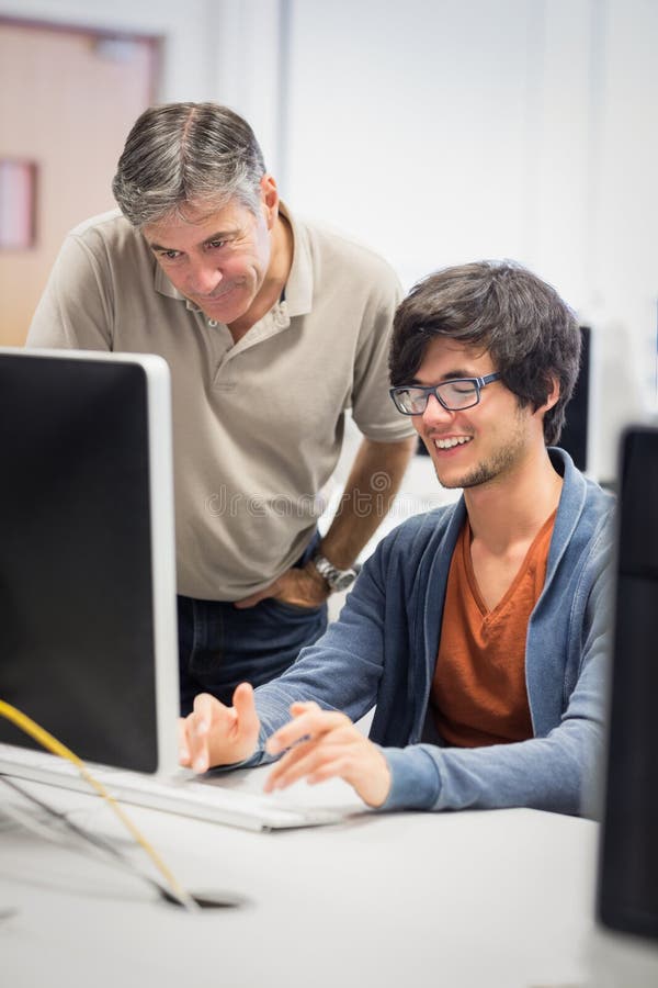Computer Teacher Assisting a Student Stock Image - Image of ...