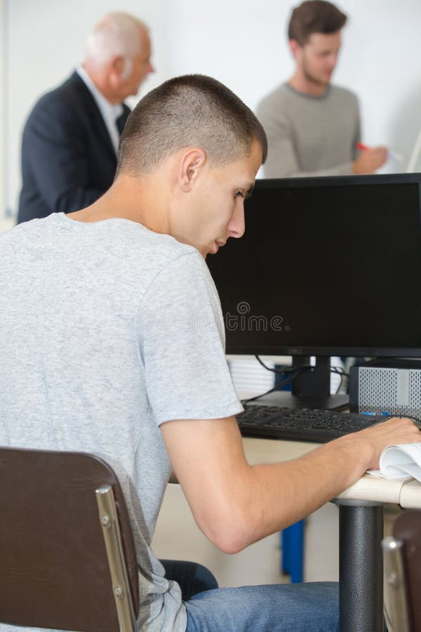 Computer Teacher Assisting Student in Classroom Stock Photo - Image of ...