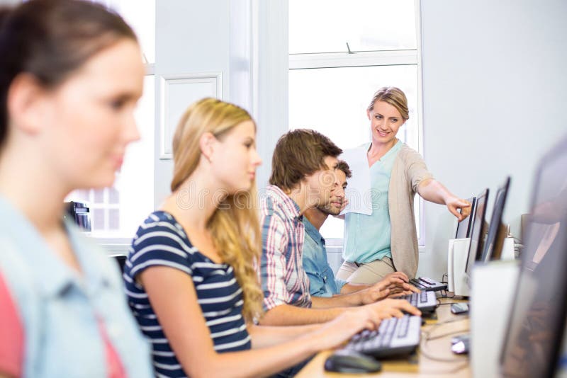 Teacher Helping Students on Laptop Stock Image - Image of people ...
