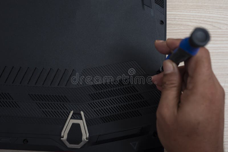 A Computer Technician Removes the Bottom Cover Panel of a Laptop with a ...