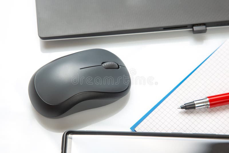 Computer Wireless Mouse, Pen and Notepad Next To a Laptop on a White ...
