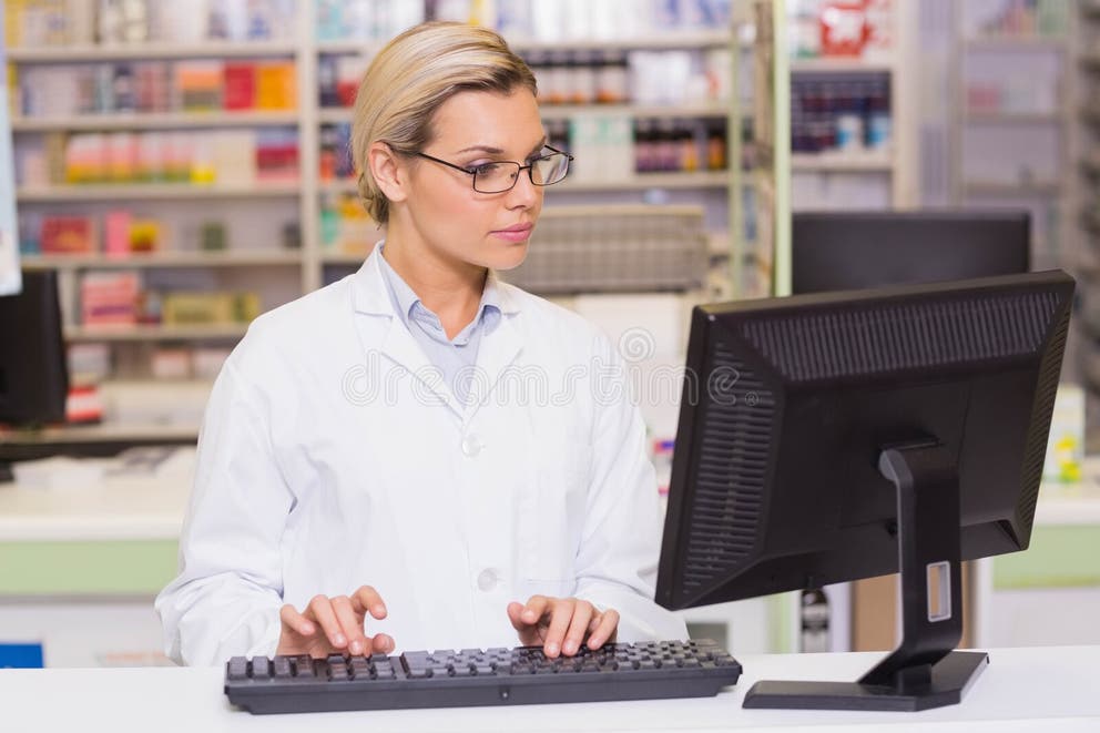 Female Pharmacist in Lab Coat Typing on Keyboard at Pharmacy Counter ...
