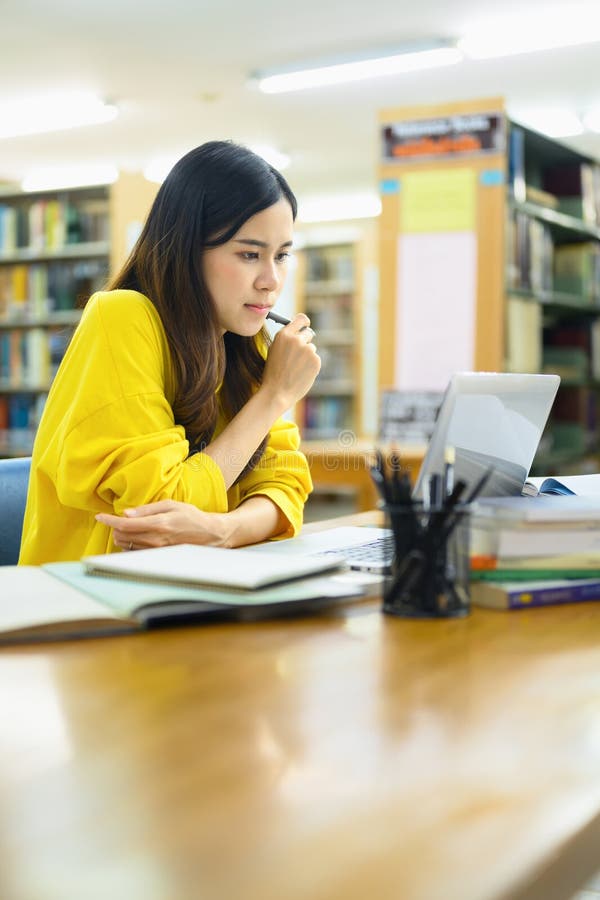 Concentrated Asian Female Student Doing Class Assignment and Searching ...