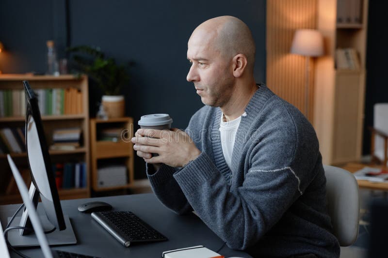 Concentrated Bald Man with Coffee Cup Using Computer while Working at ...