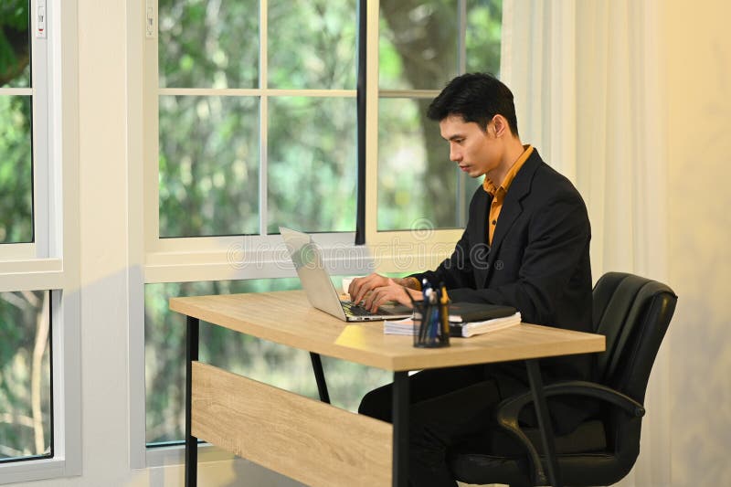Concentrated Businessman Working on Laptop in Quiet Office Environment ...