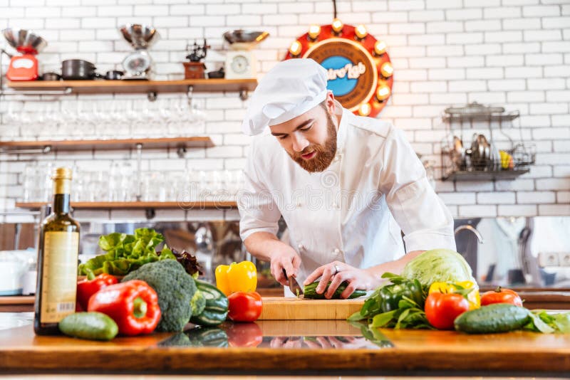 Concentrated Chef Cook Standing and Cutting Fresh Vegetables Stock ...