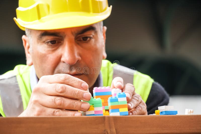 Construction Worker Using Colourful Toy Bricks Stock Photo - Image of ...