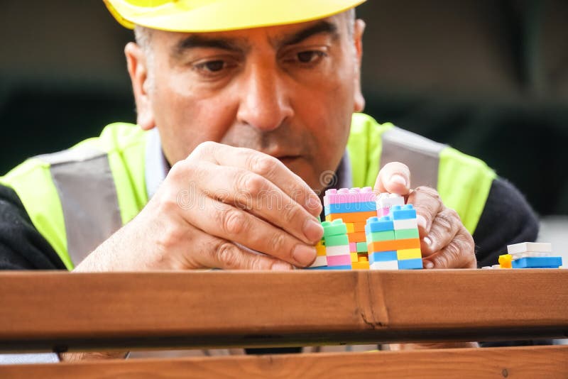 Construction Worker Using Colourful Toy Bricks Stock Photo - Image of ...