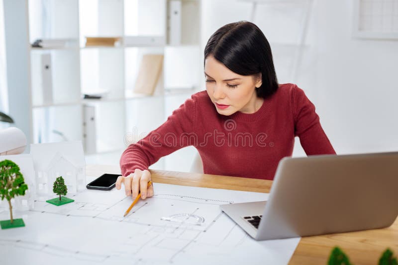 Concentrated Engineer Looking Attentively at the Drawing while Working ...