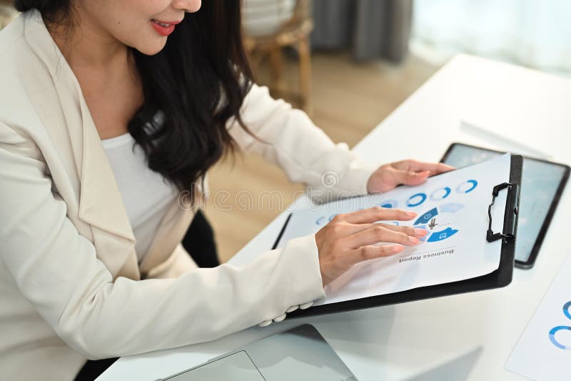 Concentrated Female Economist Analyzing Financial Data and Using Laptop ...