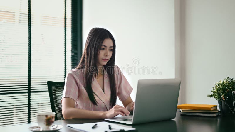 Concentrated Female Office Worker Searching Online Information on ...