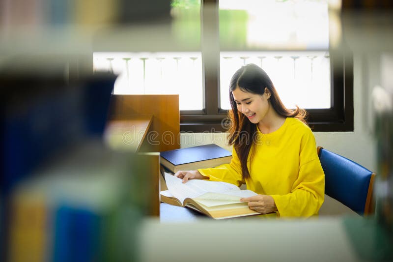 Concentrated Female Student Reading Book, Doing Class Assignment in ...