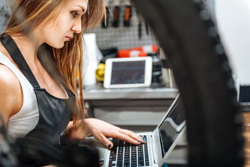 Concentrated Female Technician Using the Gadget in the Workshop Stock ...