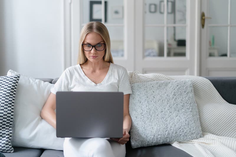 Young Woman Freelancer with Laptop on Sofa in Apartment Stock Photo ...