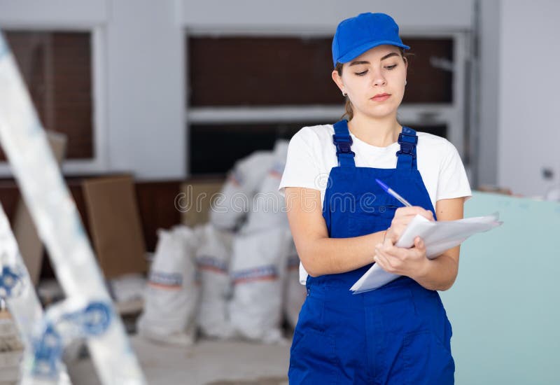 Concentrated Forewoman Making Notes on Papers at Construction Site ...