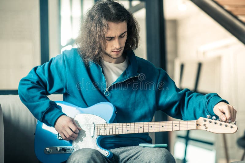 Concentrated Good-looking Unusual Guy Setting Up Strings on His ...
