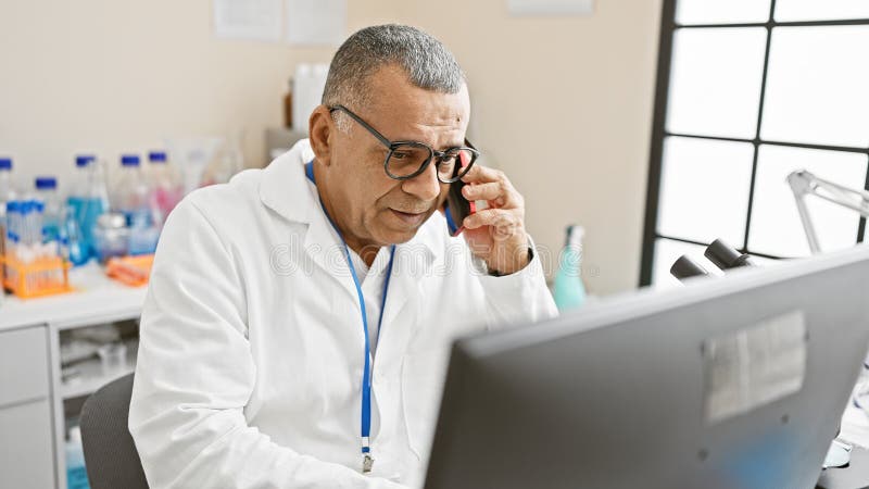 Concentrated Hispanic Man Wearing Glasses and Lab Coat Analyzing Data ...