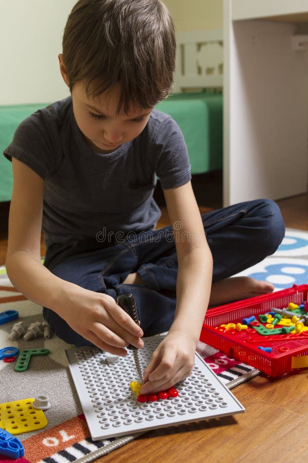 Concentrated Kid Playing with Toys Construction Tool Kit while Sitting ...