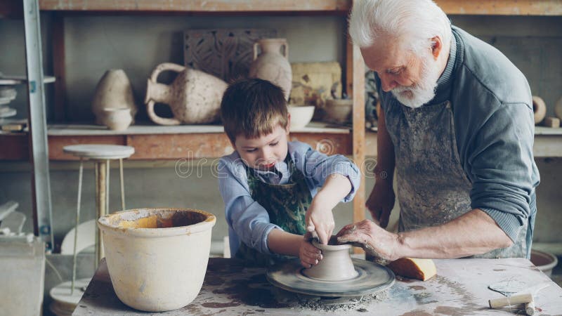 Concentrated Little Boy is Learning To Work with Clay on Throwing-wheel ...