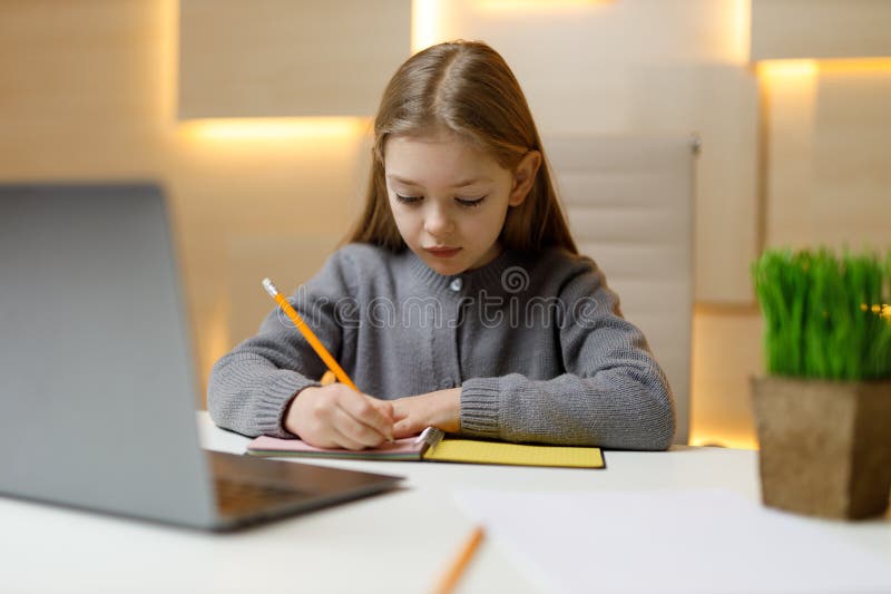 Concentrated Little Girl Writes in a Notebook, Studying at School Stock ...