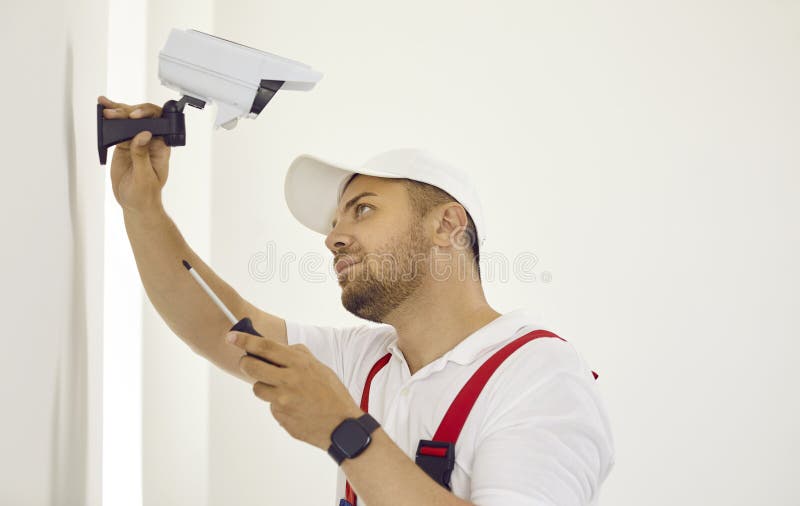 Concentrated Male Installer is Using Screwdriver To Mount CCTV Camera ...
