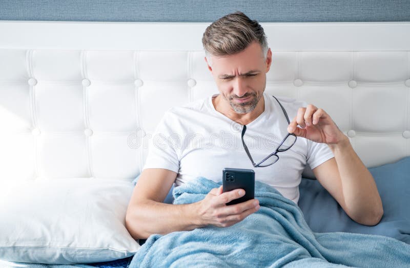 Concentrated Man in Bed Read Phone Wearing Eyeglasses Stock Image ...