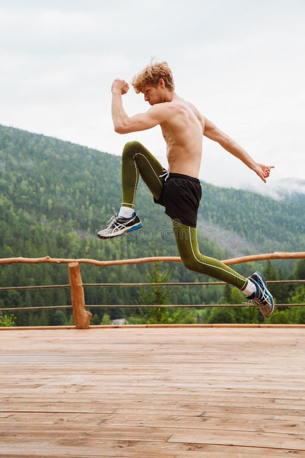 Concentrated Man Jumping during Workout on Terrace in Mountains Stock ...