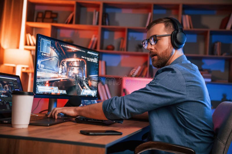 Concentrated Man is Playing the Shooter Game on His Computer. Neon ...