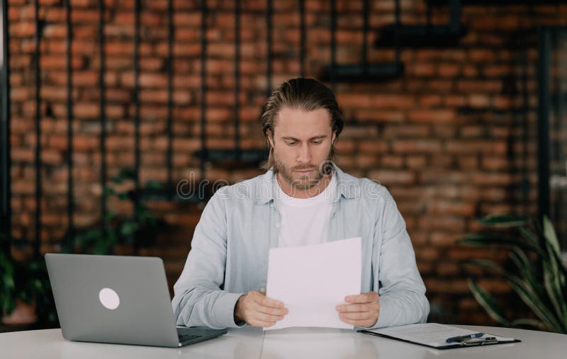 Concentrated Man Reading Contract Sitting at the Desk. Employee Reading ...