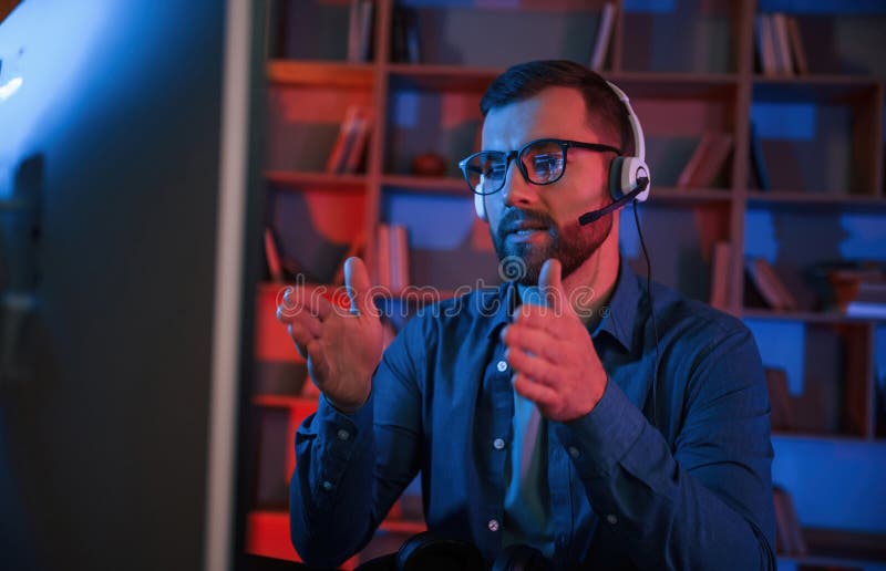 Concentrated Man is Sitting by a Computer Indoors at Home. Neon ...