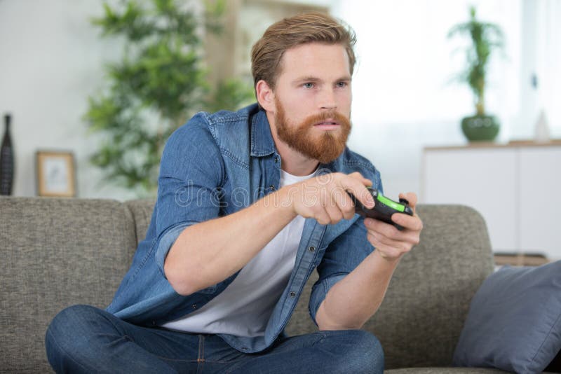 Concentrated Man Sitting on Sofa and Playing Computer Games Stock Image ...