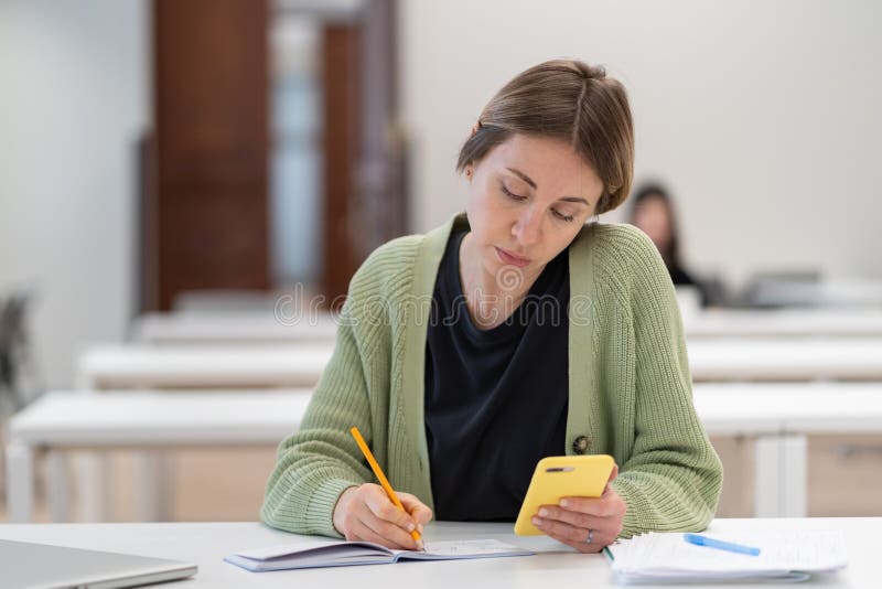 Concentrated Mature Female Student Using Smartphone for Exam ...