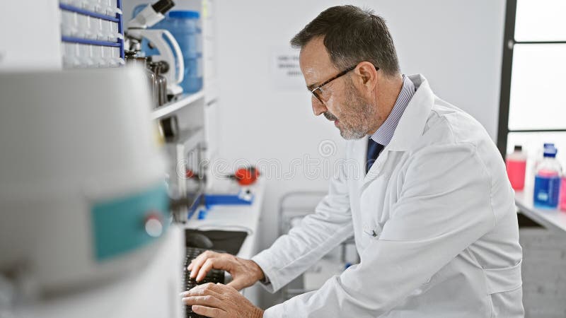 Concentrated Middle-aged Man with Grey Hair, Immersed in Groundbreaking ...