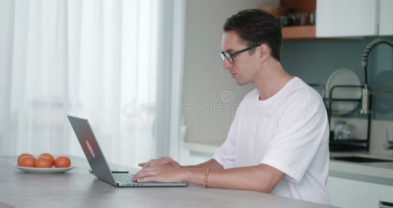 Concentrated Millennial Man in Glasses Typing on Laptop Computer ...