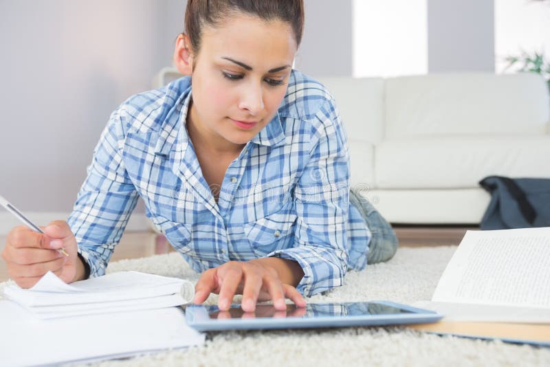 Concentrated Pretty Student Using Her Tablet for Assignments Stock ...