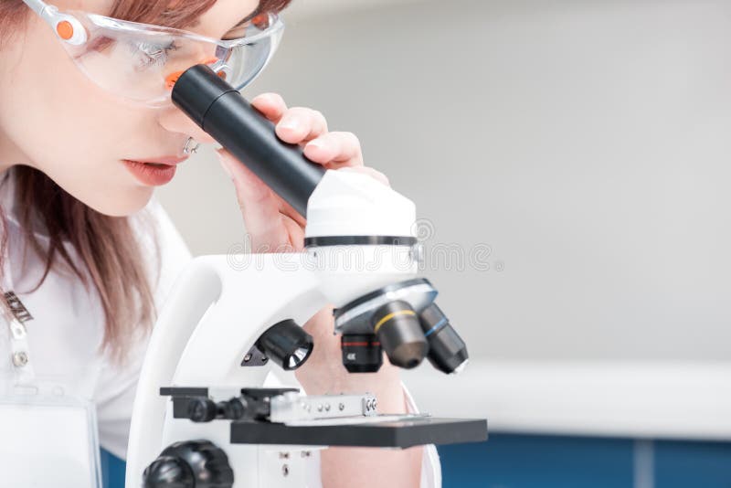 Concentrated Scientist in Lab Coat Working with Microscope in Chemical ...