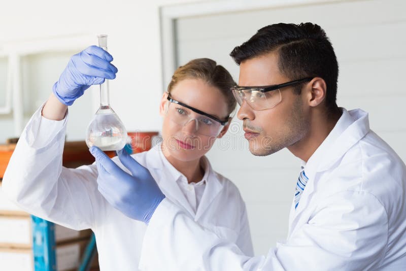 Two Scientists Observing Something with Microscope Stock Photo - Image ...