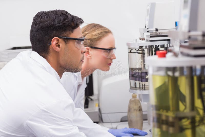 Two Scientists Observing Something with Microscope Stock Photo - Image ...