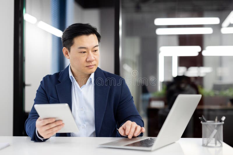 Concentrated and Serious Asian Man Working in the Office Using a ...