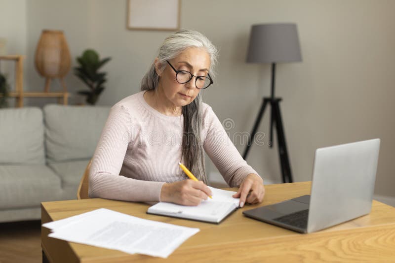Concentrated Serious Busy Pretty Caucasian Old Lady in Glasses Makes ...