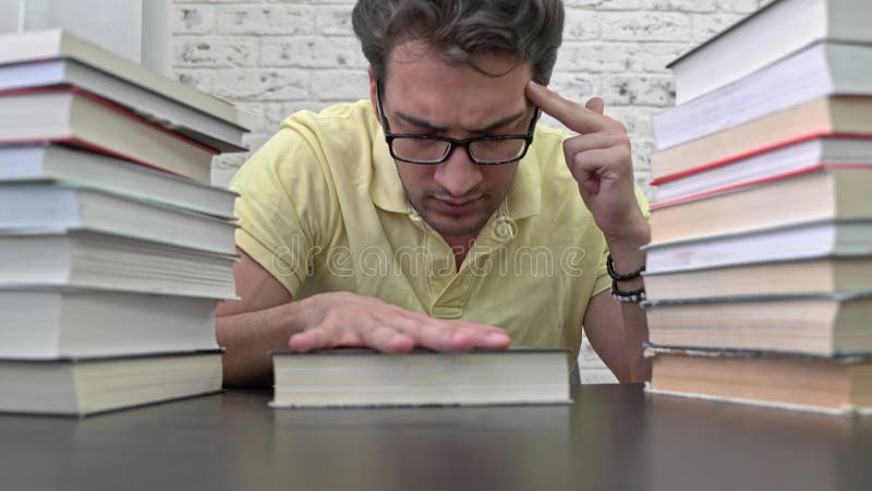 Stressed Student Studying and Taking Notes in the Library Surrounded by ...