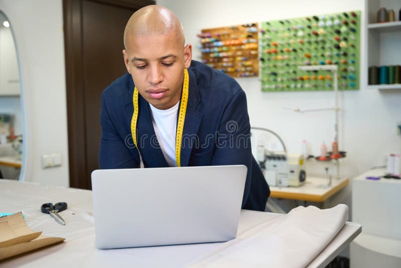 Concentrated Tailor Working on Laptop in His Sewing Workshop Stock ...