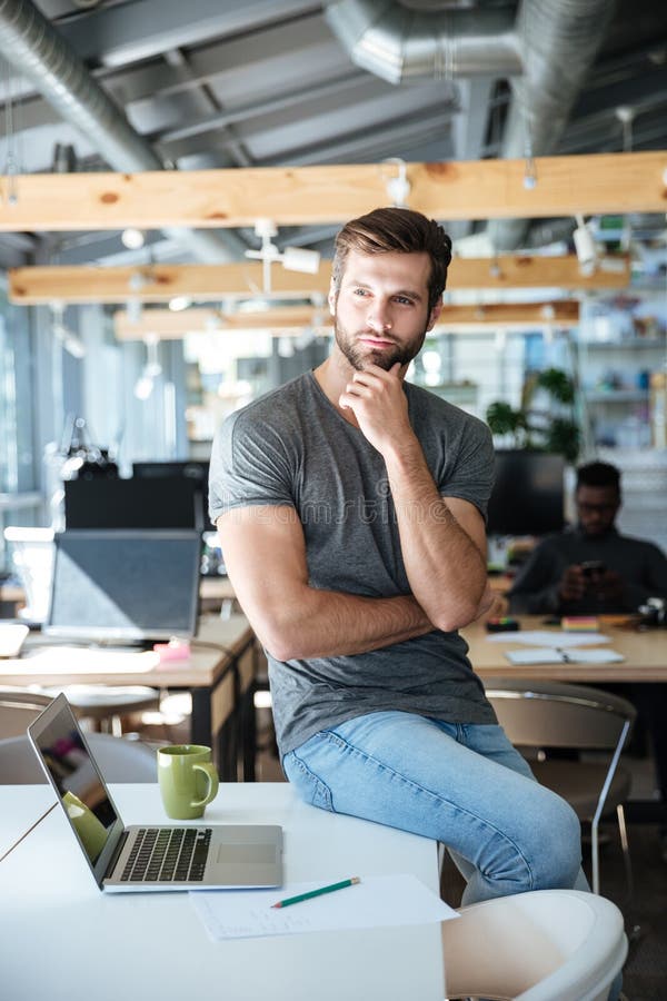 Concentrated Thinking Young Man Sitting on Table in Office Stock Photo ...