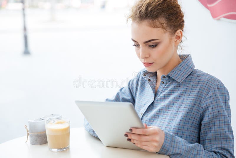 Concentrated Woman Drinking Coffee and Using Tablet in Cafe Stock Image ...
