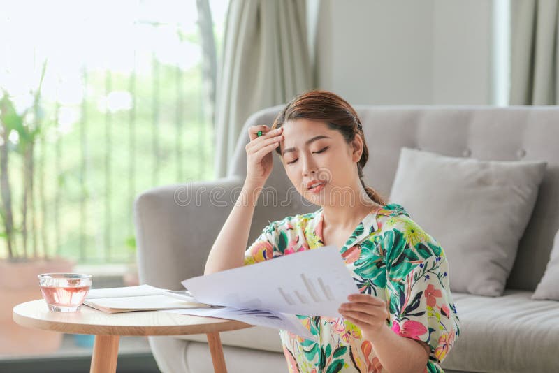 Concentrated Woman Sitting at Desk Looking at Papers Reading Stock ...