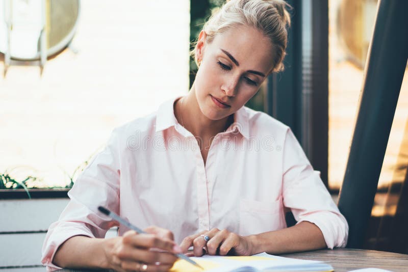 Concentrated Woman Writing in Notebook in Cafe Stock Image - Image of ...