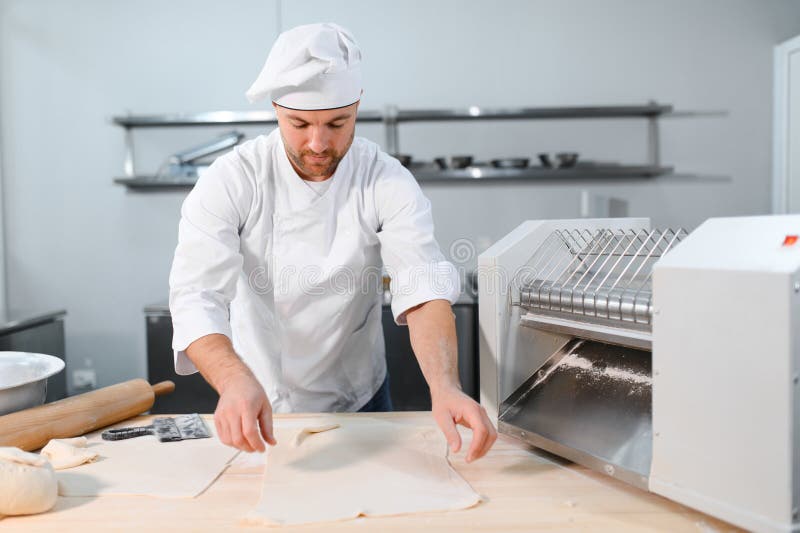 Concentrated at Work. Handsome Chef Rolling a Dough through Pasta ...