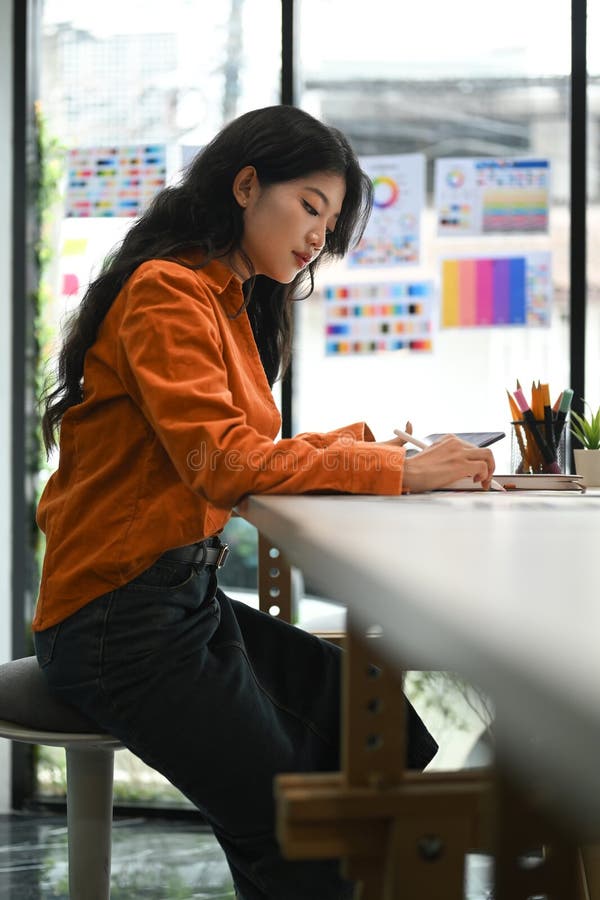 Concentrated Young Creative Woman Sitting in Bright Office and Working ...