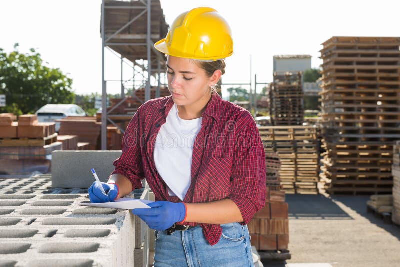 Concentrated Young Girl Worker, Keeps Records of Construction Materials ...